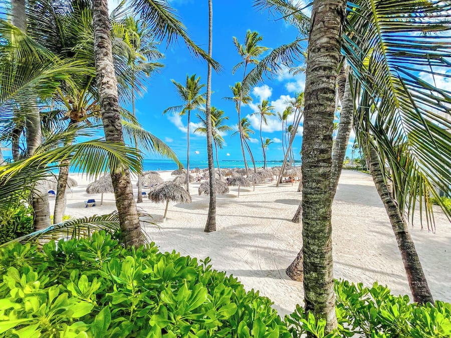 Na praia, praia de areia branca, espreguiçadeiras, guarda-sóis de praia