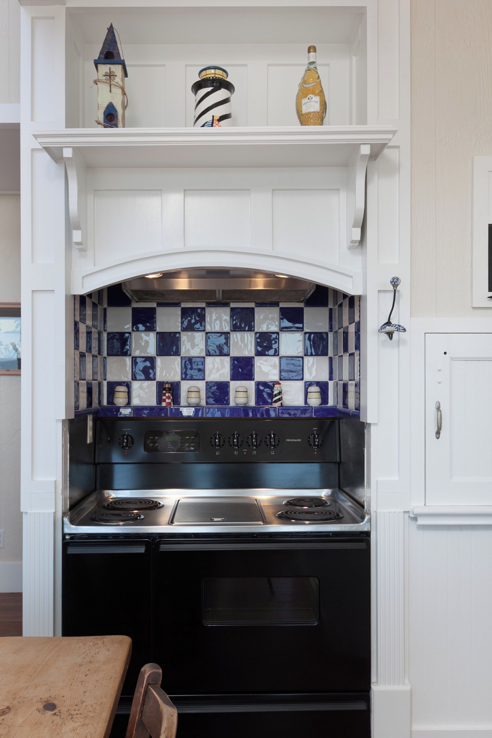 Cozinha com fogão, forno e painel de azulejos.