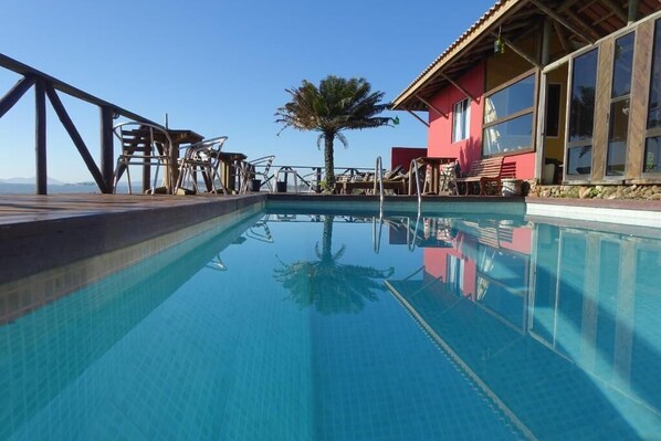 Piscina externa, guarda-sóis, espreguiçadeiras