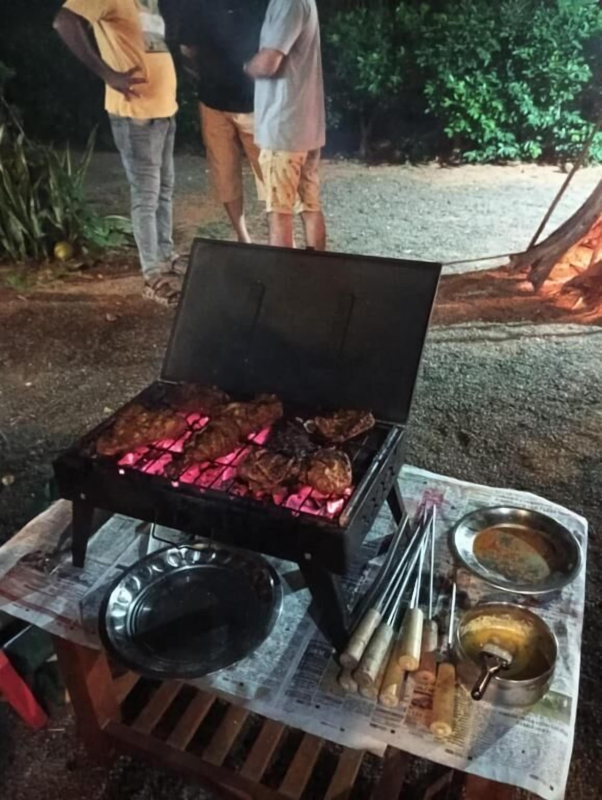 Churrasqueira com carne assando ao ar livre.