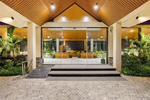 Um saguão de hotel com teto de madeira, balcão de recepção e área de estar.