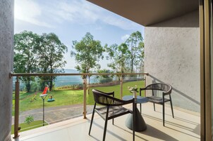Uma varanda com vista para uma paisagem verde e uma cordilheira distante.