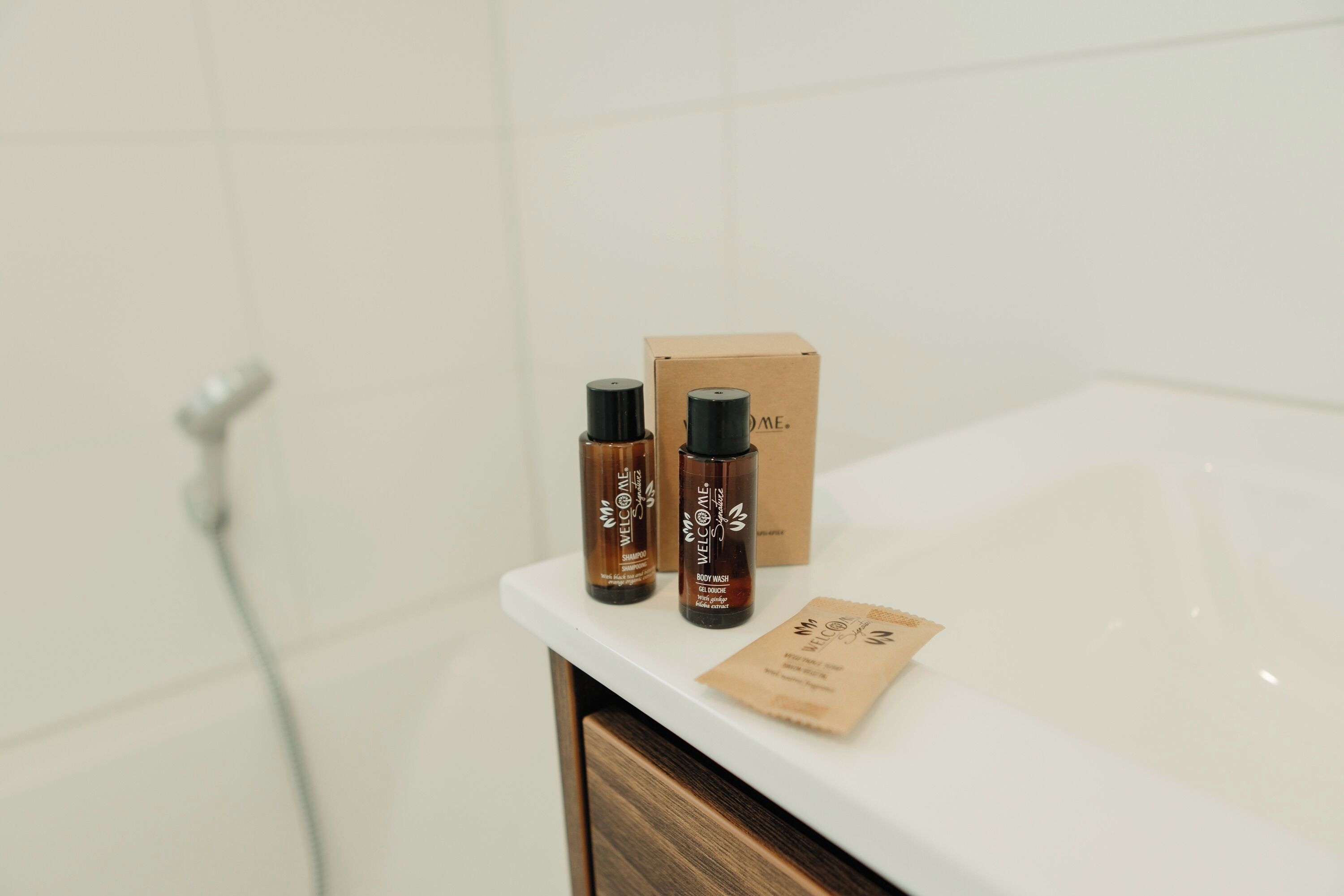 Casa de banho com bancada branca, duas embalagens de gel de banho e uma caixa.