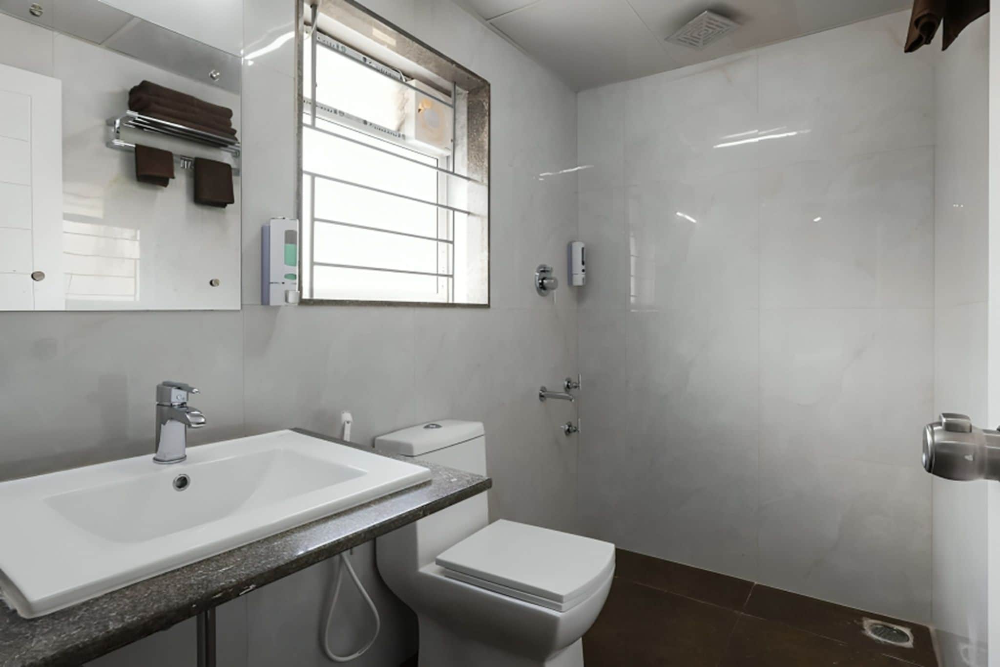 Uma casa de banho moderna com lavatório, sanita e chuveiro.