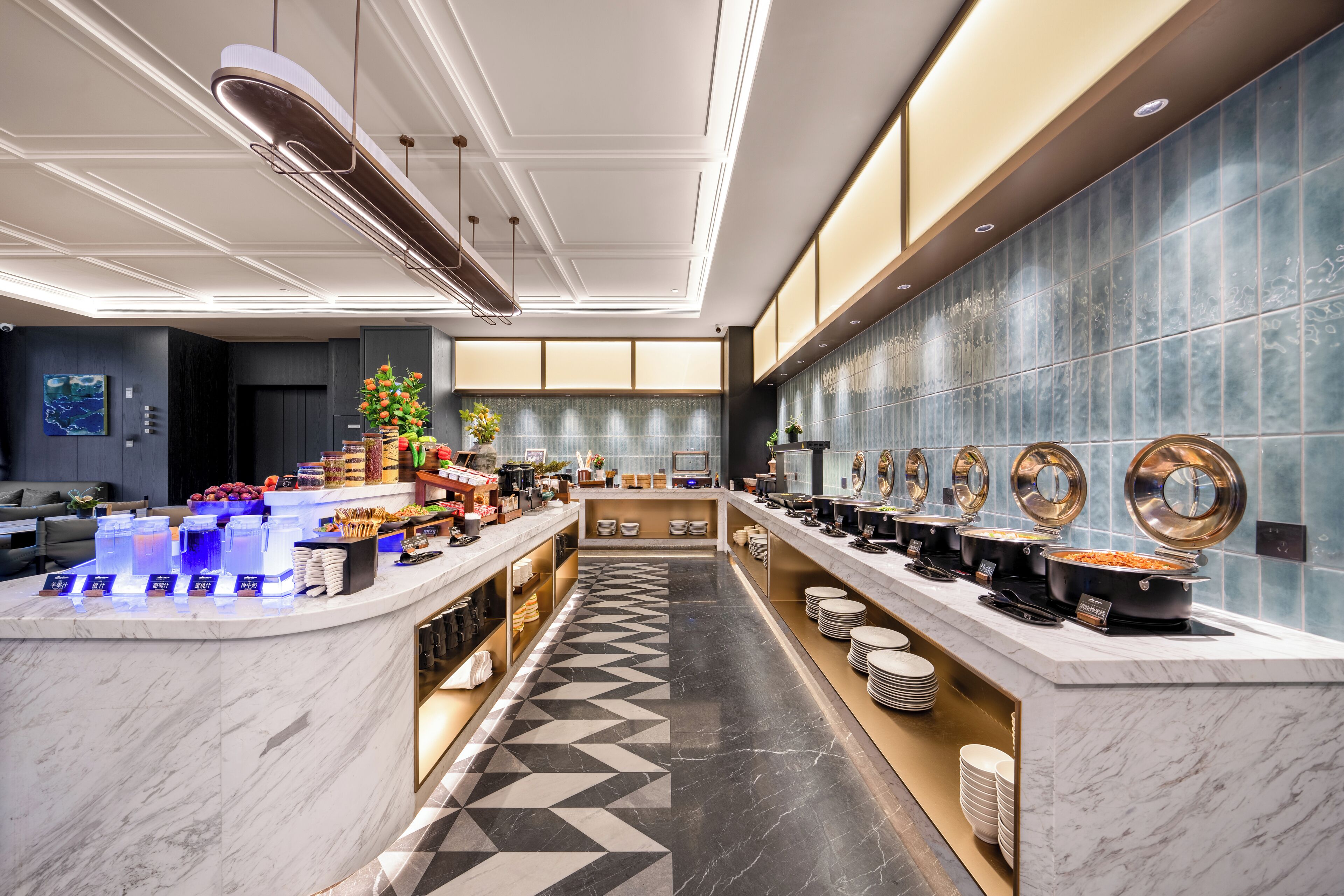 Um hall de hotel moderno com piso de mármore, balcão de recepção e área de buffet com estações de comida.