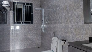 Uma casa de banho moderna com sanita, bidé e área de duche.