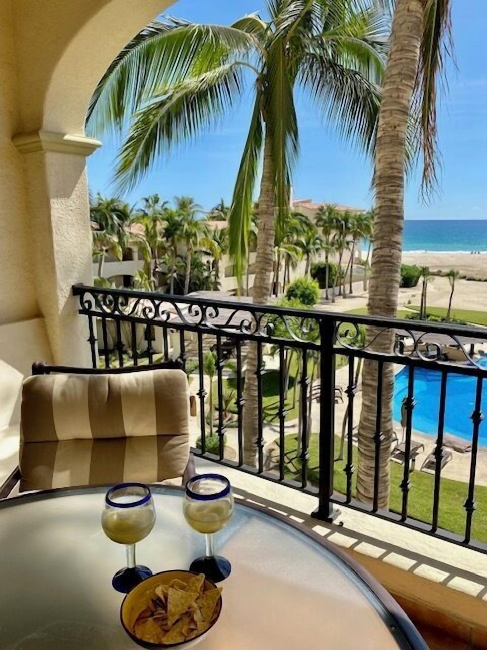 Varanda com vista para uma praia e uma piscina.