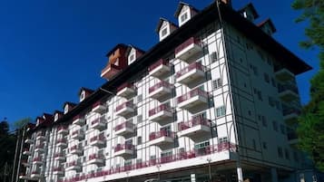 Hotel de vários andares com varandas e céu claro.