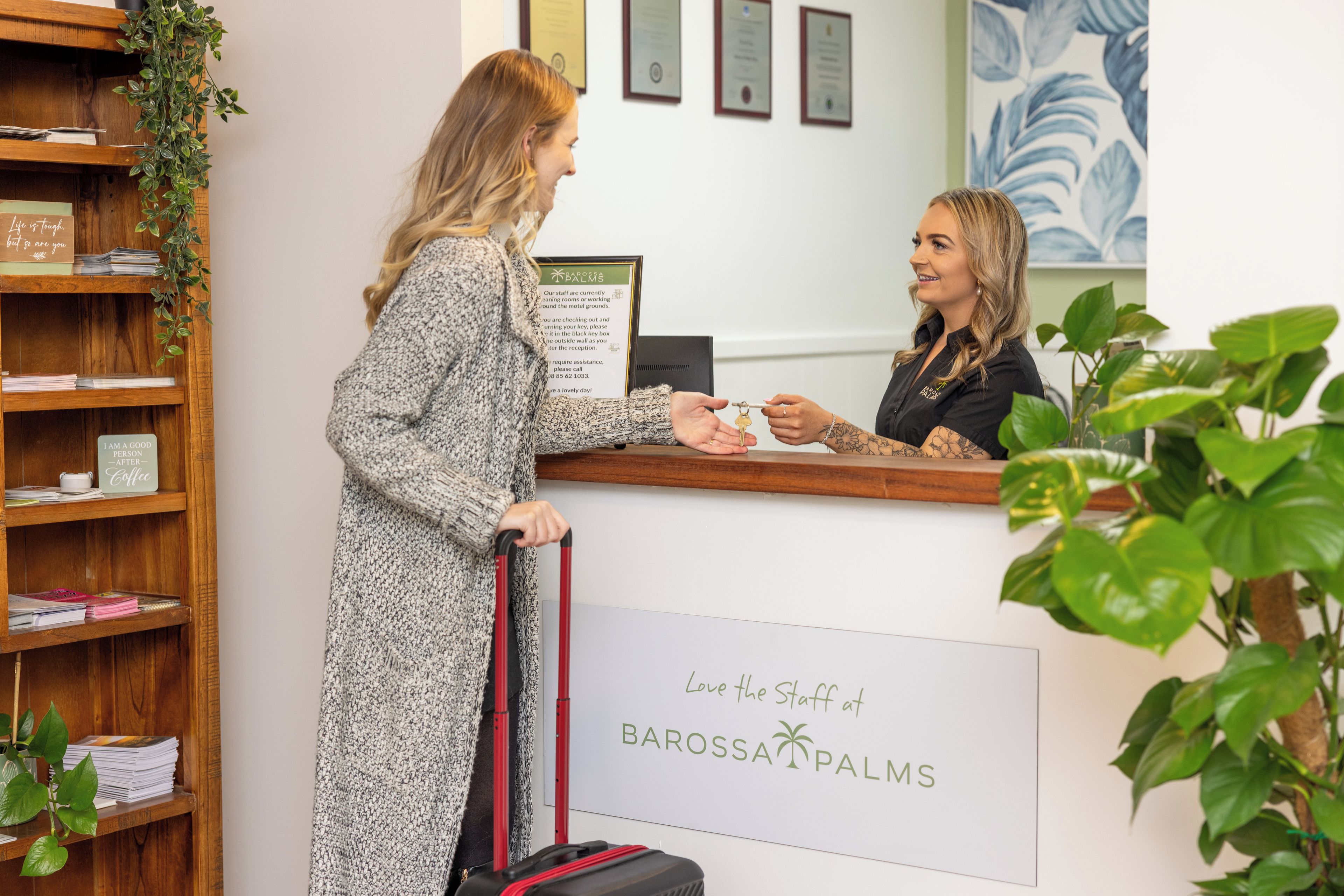 Uma mesa de recepção com uma placa que diz 'Ame a equipe do Barossa Palms'.