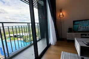 Varanda com vista para a piscina, televisão e abajur.