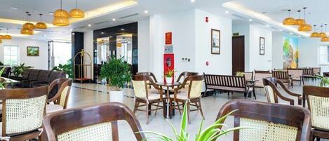 Um hall amplo com mobiliário de madeira, cadeiras de vime e luminárias pendentes de vime.