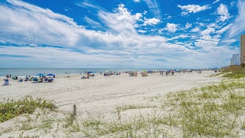 Na praia, guarda-sóis de praia, toalhas de praia