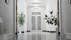 Um hall de hotel moderno com piso lustroso, design simétrico e planta central.
