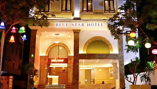 Um hotel com uma entrada imponente, uma placa com a inscrição "BLUE STAR HOTEL" e uma área de recepção visível.