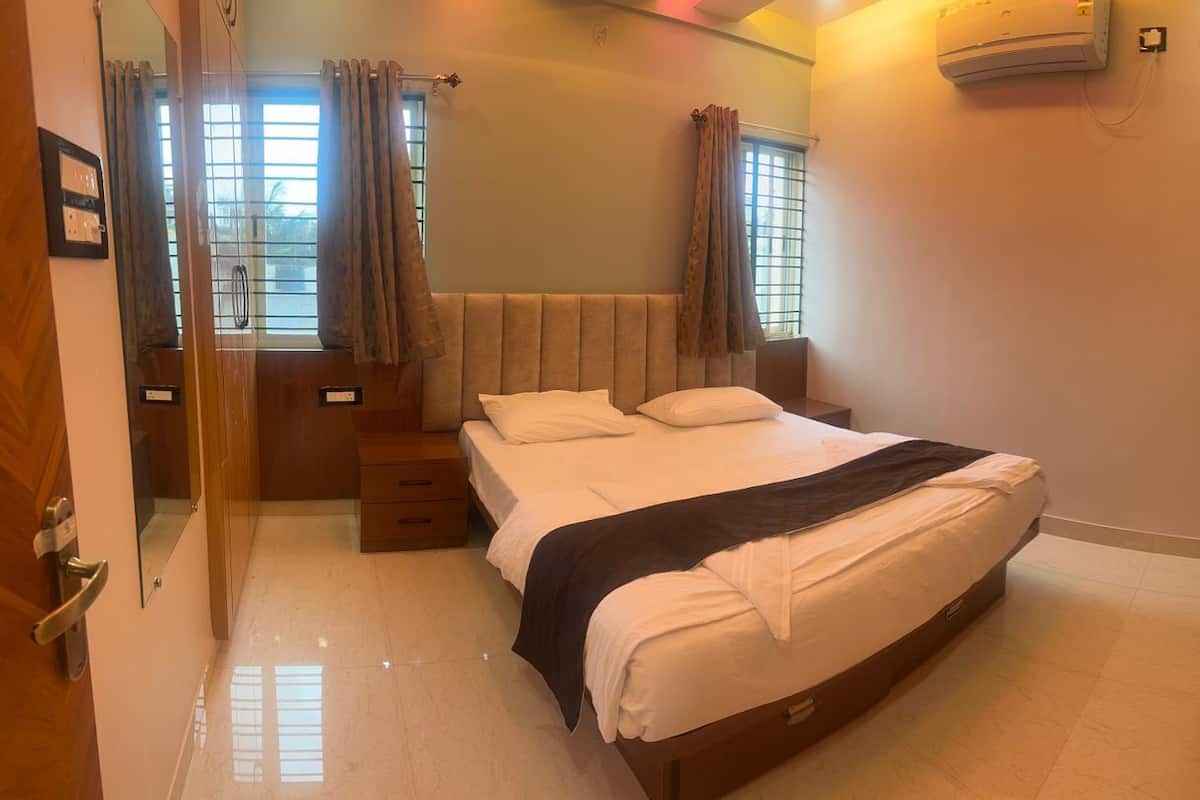Quarto com cama grande, guarda-roupa e ar condicionado.