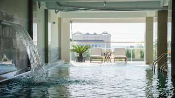 Piscina interior, guarda-sóis, espreguiçadeiras