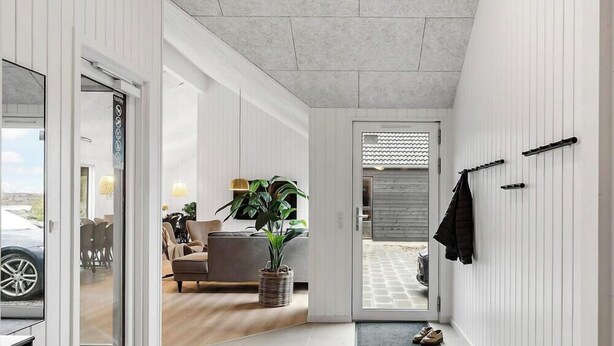 Interior moderno com um corredor que leva a uma sala de estar, sala de jantar e vista para o exterior.