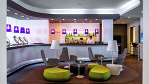 Uma área de estar moderna, com assentos, um bar e uma receção.