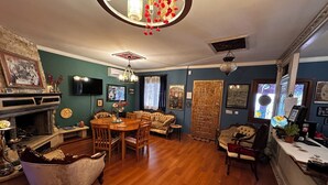 Uma sala de estar espaçosa com lareira, área de refeições e um espaço de estar aconchegante.