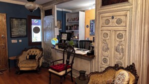 Um quarto com móveis de madeira ornamentados, um globo no escritório e uma estante repleta de livros.