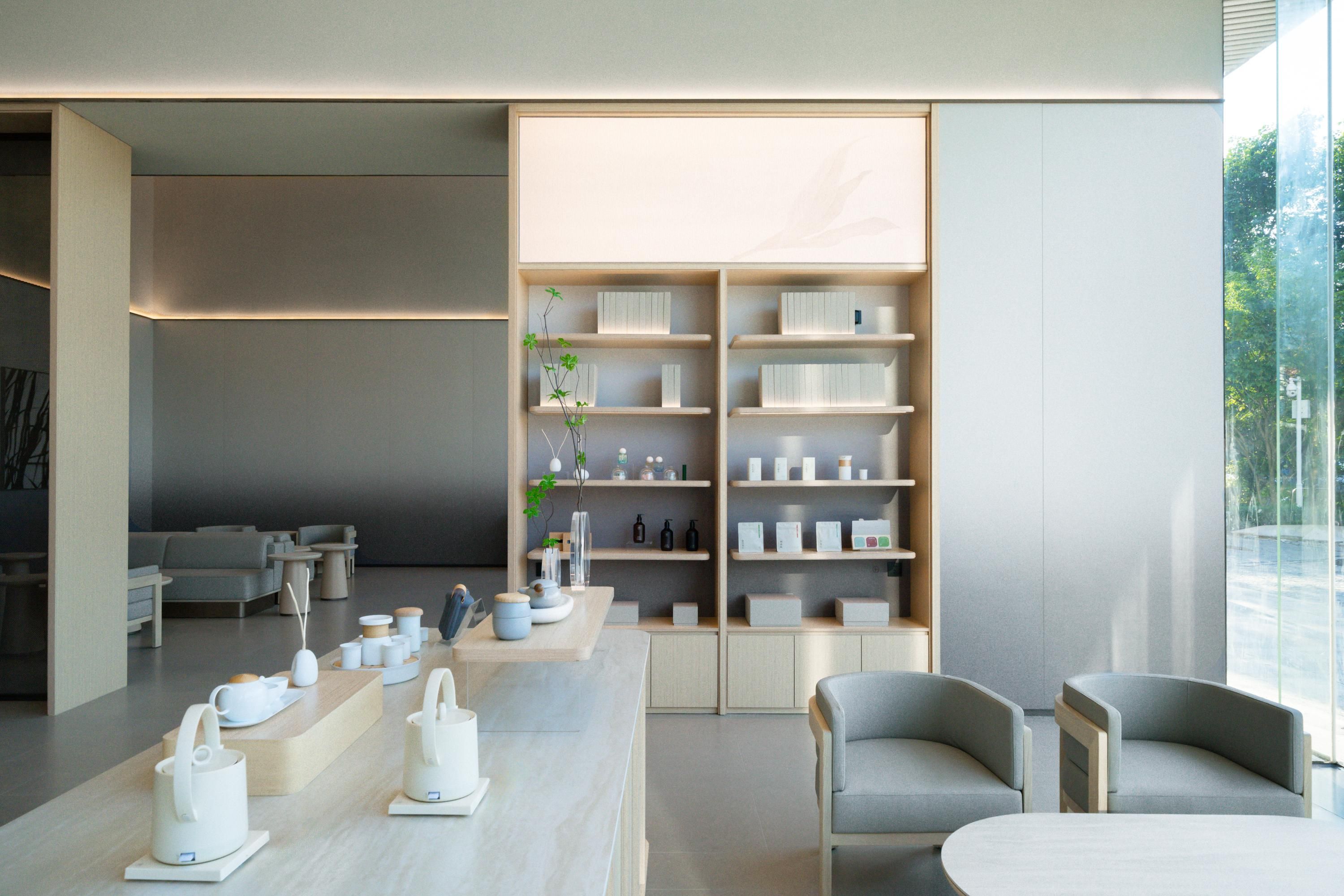 Um interior moderno com uma mesa central, área de estar e estantes embutidas.