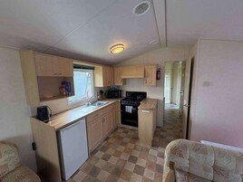 Um frigorífico, um micro-ondas, um forno, uma placa de cozinha 