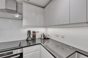 Apartamento Superior, 3 quartos | Cozinha privada | Uma cadeira de bebé, utensílios de cozinha