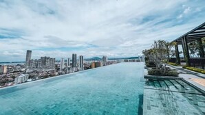 Piscina infinita no terraço com vista para a cidade.