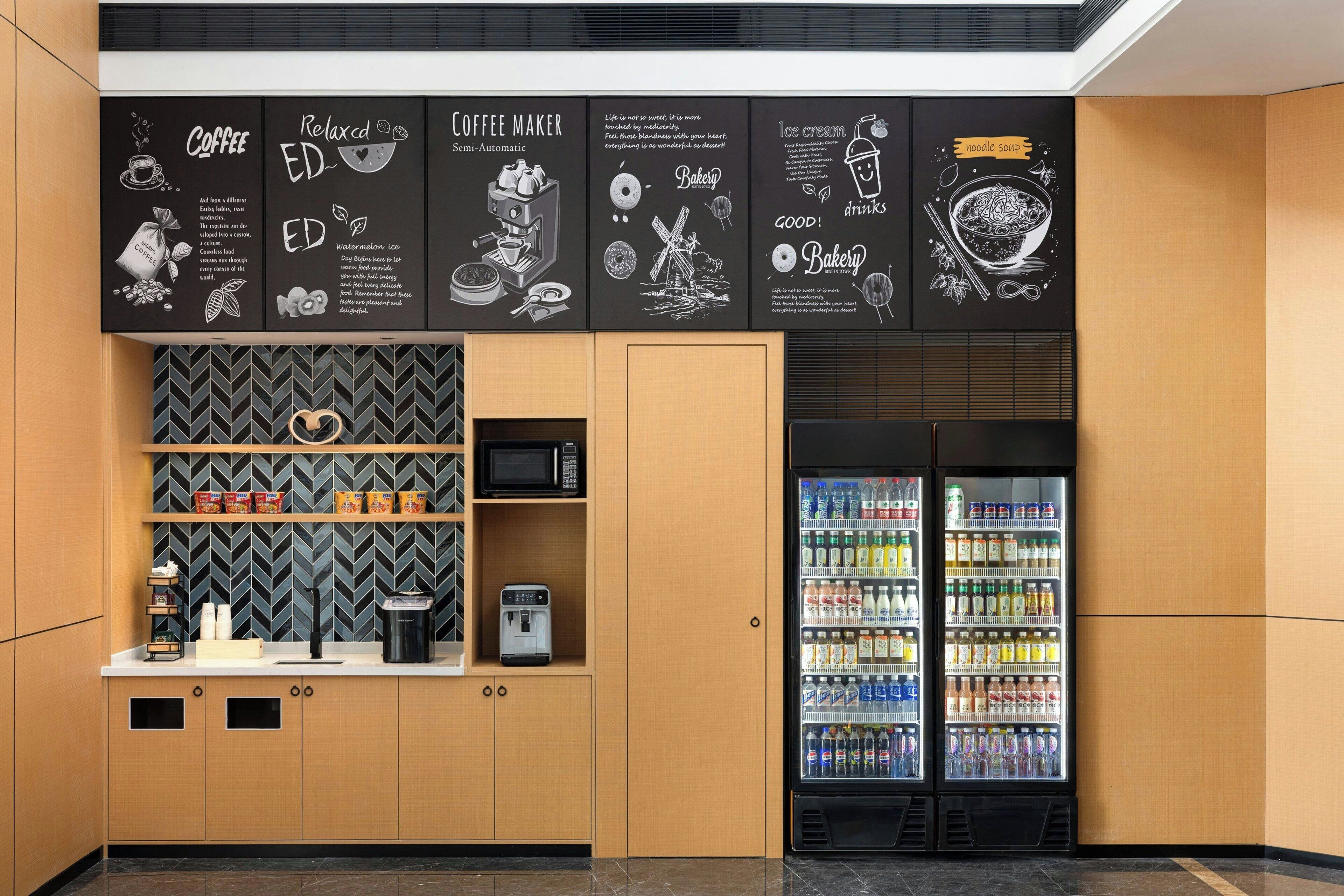 Uma cozinha compacta moderna com cafeteira, micro-ondas e dispensador de bebidas.