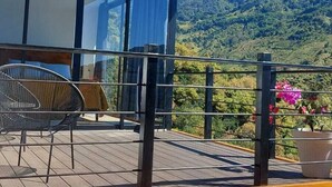 Um edifício moderno com varanda e vista para uma paisagem montanhosa.