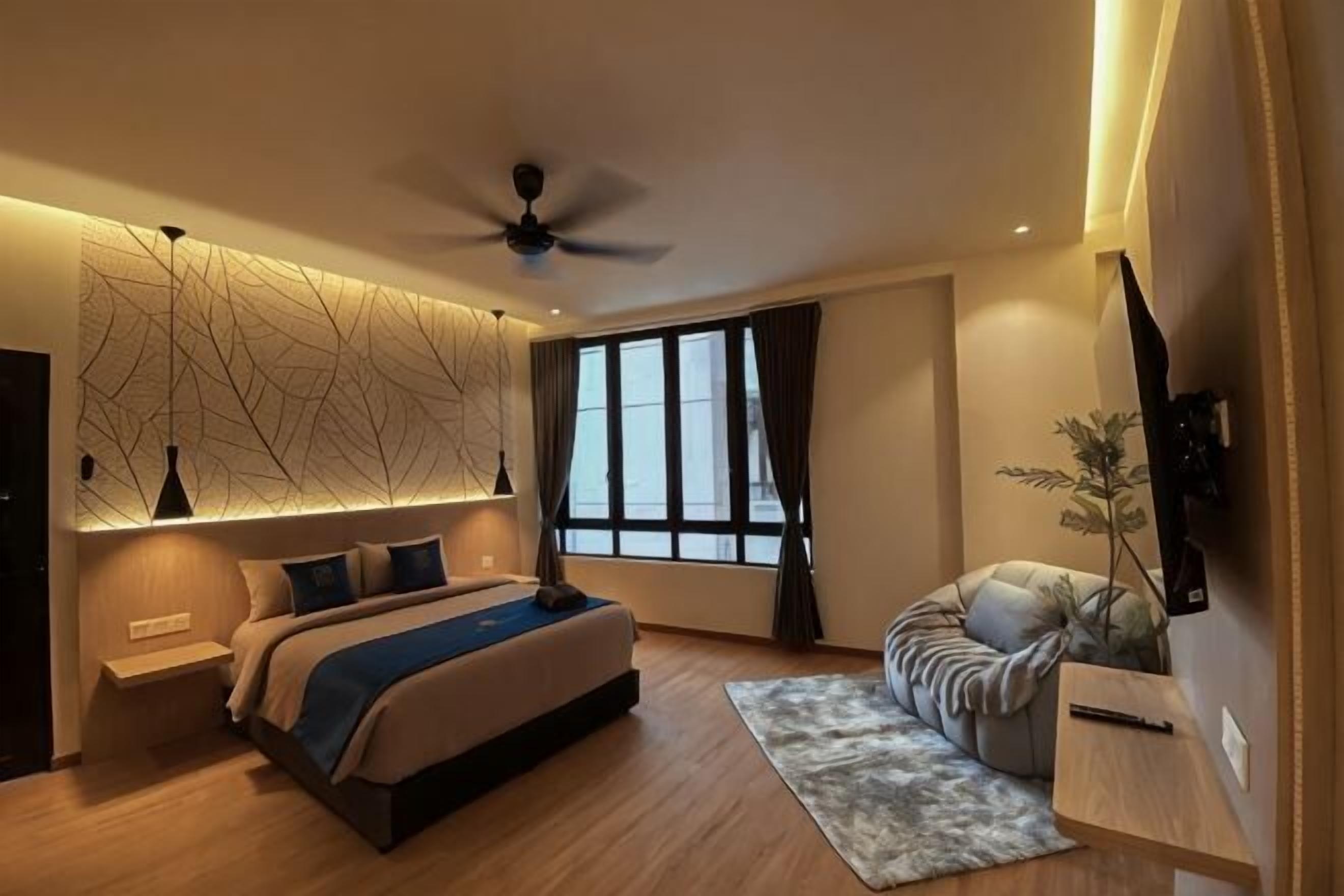 Quarto moderno com cama, ventoinha no teto, janela ampla e televisão na parede.