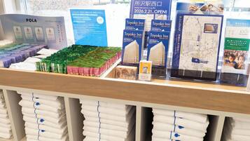 Exposição de hotel com toalhas bem organizadas, uma seção de produtos de skincare POLA e material promocional para Toyoko Inn.