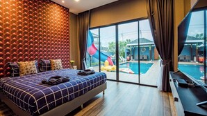 Quarto de hotel moderno com cama grande, vista para uma piscina e parede acústica vermelha.