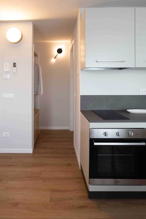 Apartamento Deluxe | Cozinha privada | Um frigorífico, uma placa de cozinha, utensílios de cozinha