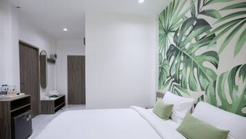Quarto de hotel com cama, escrivaninha, guarda-roupa e um grande mural na parede.