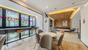 Uma sala de conferência moderna com uma janela grande, uma mesa redonda e várias cadeiras.