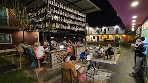 Zona de bar com diversos arranjos de assentos e um grande mostrador de bebidas.