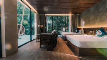 Quarto de hotel moderno com uma janela grande, duas camas, uma mesa e vista para o exterior.