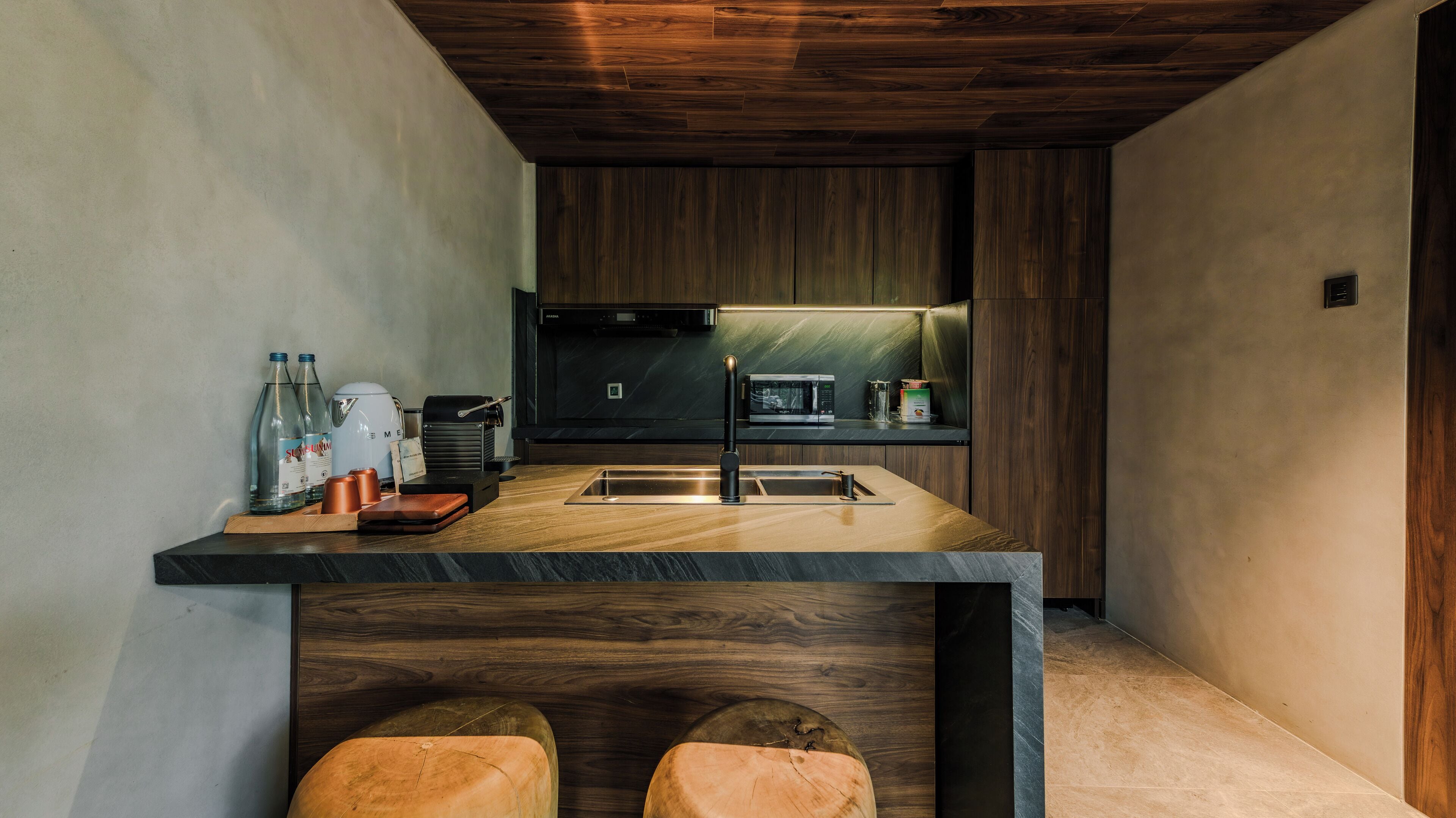 Uma cozinha moderna com uma ilha central, micro-ondas e máquina de café.