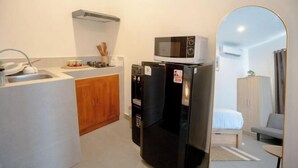 Uma cozinha compacta com micro-ondas, geladeira e armários de madeira.