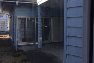Uma casa com porta de garagem, porta de correr e uma janela.