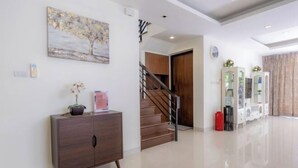 Um interior moderno com escada de madeira, um armário com planta em vaso e um quadro na parede.
