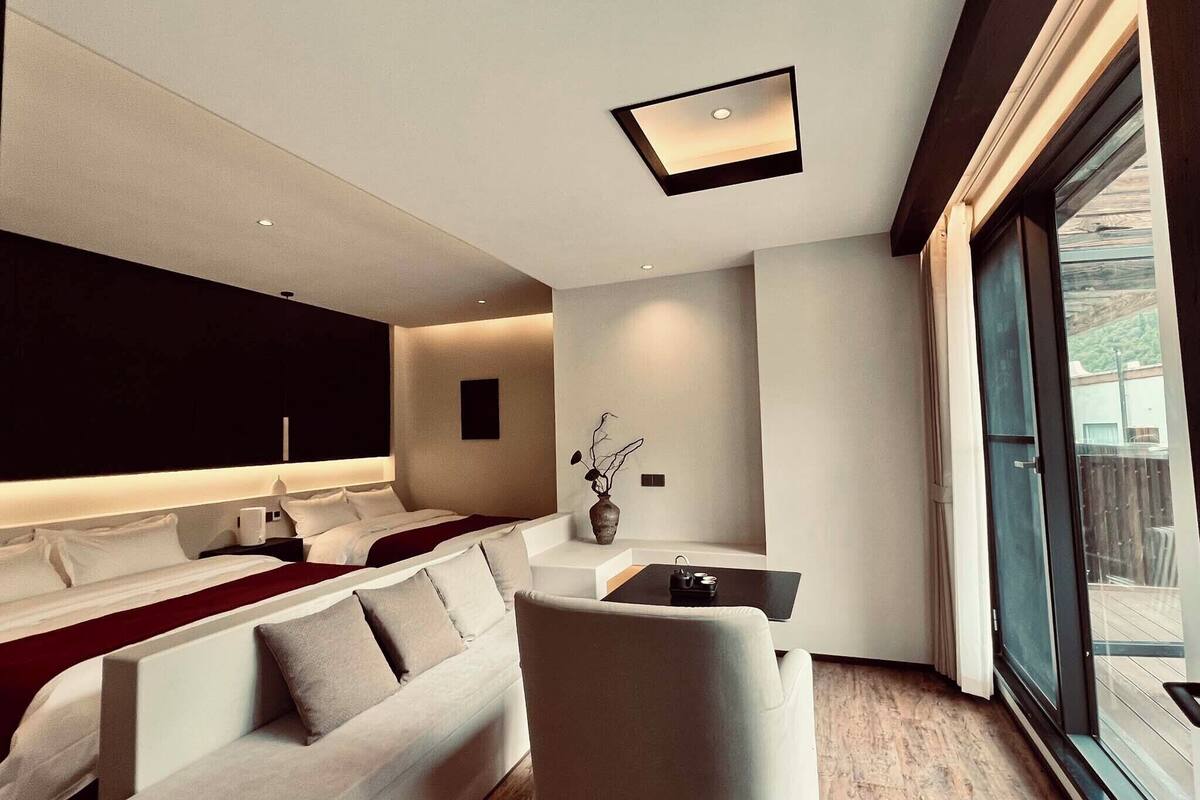 Uma sala de estar moderna com um sofá, uma mesa de centro e uma janela grande.