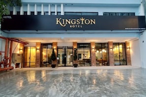 Exterior do Hotel Kingston, com fachada moderna, grandes portas de vidro e entrada bem iluminada.