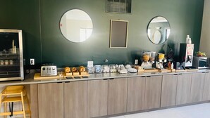 Uma bancada de cozinha com cafeteira, torradeira e diversos alimentos.