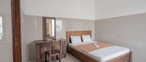 Um quarto com uma cama de madeira, uma escrivaninha com cadeira e um espelho.