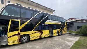 Um ônibus de dois andares estacionado em frente a um edifício com arquitetura moderna.