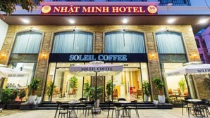Exterior do HOTEL NHAT MINH, com uma cafeteria chamada SOLEIL COFFEE em frente.