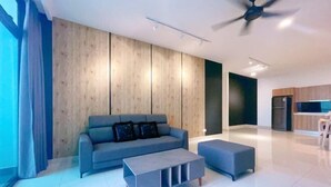 Uma sala de estar moderna com sofá, apoio para os pés e ventilador de teto.