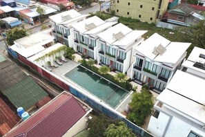 Área residencial com casas modernas, piscina e quadra de tênis.